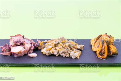 맛있는 절인 홍합 얇게 썬 포톤 맛있는 코클이 검은 소박한 돌 판에 담긴 고급스러운 요리입니다 갑각류에 대한 스톡 사진 및 기타