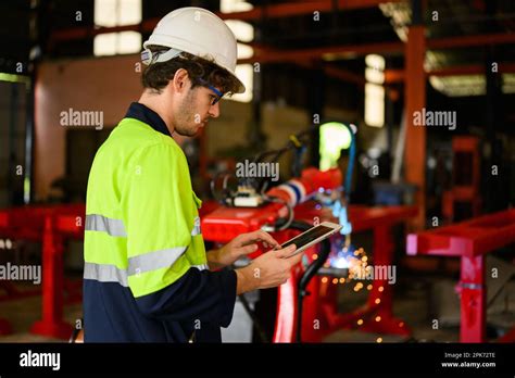 Young Industrial Engineer Holding Tablet Checking And Controlling