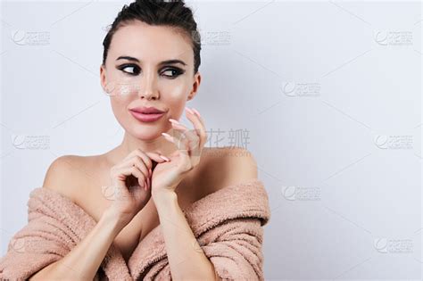 美丽的年轻女子与清洁新鲜的皮肤触摸她的脸特写