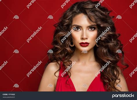 زن زیبایی سبزه با موهای مجعد مشکی و آرایش لب های قرمز عالی مدل مد با مدل موی بلند موج دار و