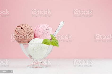 달콤한 아이스크림 공 딸기 초콜릿 숟가락우아한 투명 유리 그릇에 크림 흰색 나무 테이블에 녹색 민트 분홍색 벽 3가지 개체에