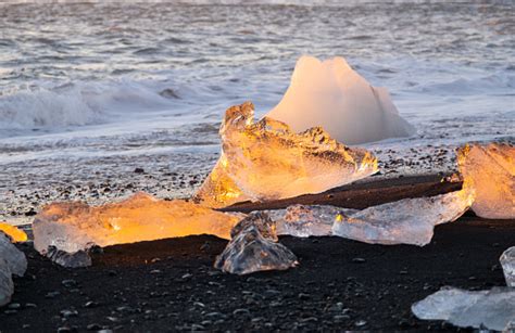 아이슬란드의 다이아몬드 비치 해질녘 검은 화산 모래 위에 빛나는 빙산 맑은 얼음이 파도에 의해 추락했습니다 북유럽 국가의 유명한 관광지 여행 목적지 고해상도 겨울에 대한