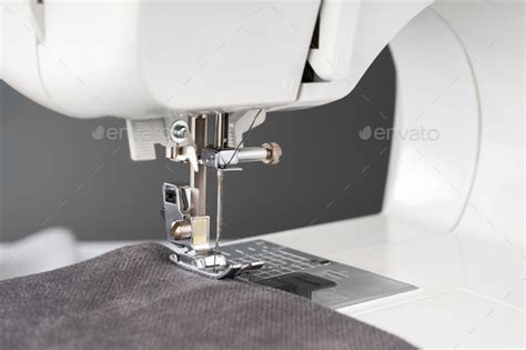 Modern Sewing Machine Presser Foot With Gray Fabric And Thread Closeup
