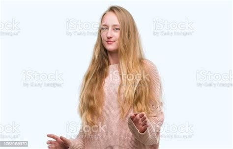 분홍색 스웨터를 입고 금발 십 대 여성 화나게 식 불쾌 하 고 두려워 하기 때문에 역 겨 운 얼굴을 하 고 혐오 반응 손으로