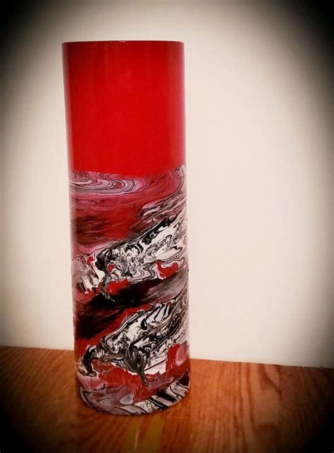 A Red Glass Vase Sitting On Top Of A Wooden Table