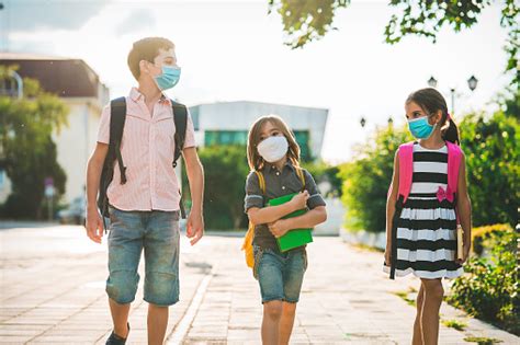 격리 중에 학교로 돌아갑니다 얼굴 보호 마스크를 착용 배낭을 가진 어린이 코비드 19 코로나바이러스 전염병 신규 표준 공간을