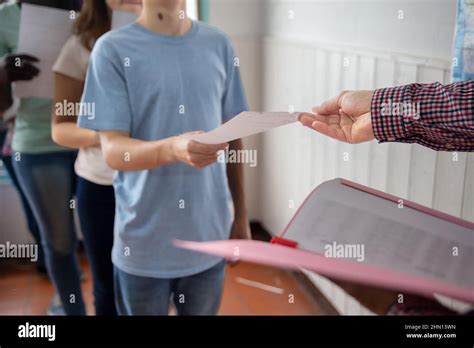 Group Of Multi Ethnic High School Students Handing In Class Assignments