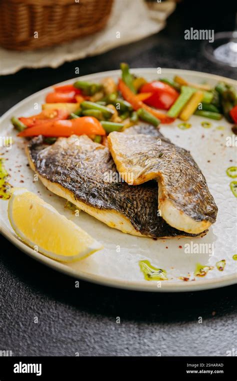 Grilled Sea Bream Fillet With Vegetables And Lemon Plated With Elegant