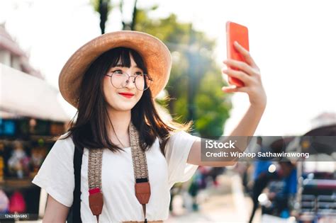 젊은 아시아 안경 소녀 힙스터 스타일 여행자 배낭 솔로 로컬 여행 셀카 와 스마트폰 카메라 20 29세에 대한 스톡 사진 및