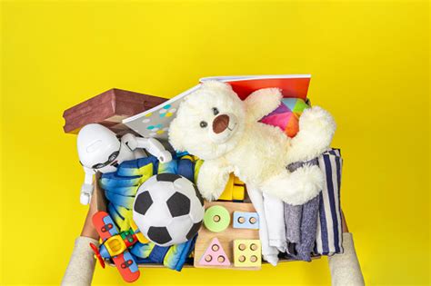 아기 장난감 책 학교 용품 노란색 배경에 자선 용 의류와 기부 상자 위쪽 보기 Charitable Foundation에 대한
