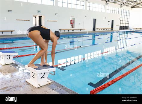 Swimmer Poised On Starting Block At Poolside With Copy Space The
