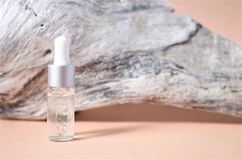 베이지 색 배경에 투명한 액체와 천연 목재가 있는 유리 드롭퍼 병 측면 보기 텍스트 장소 0명에 대한 스톡 사진 및 기타 이미지