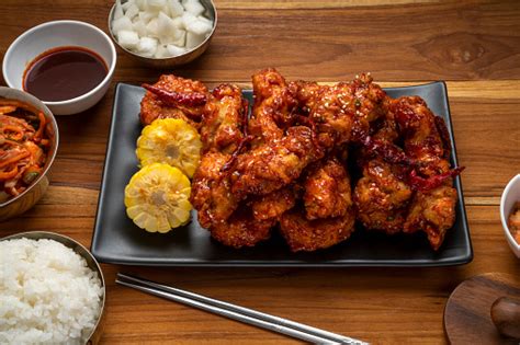 치즈 디핑 소스를 곁들인 맛있는 한국 프라이드 치킨 전통 한국 음식 프라이드 치킨 나무 테이블에 치즈를 담근 한국 떡 건강한