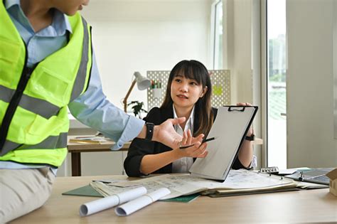 엔지니어 여성이 사무실에서 동료와 함께 건설 프로젝트를 스케치하고 검사하고 있습니다 25 29세에 대한 스톡 사진 및 기타 이미지 25 29세 2명 30 34세