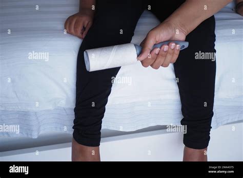 Using An Adhesive Roller To Remove Lint And Fluff From A Bed Stock Photo Alamy