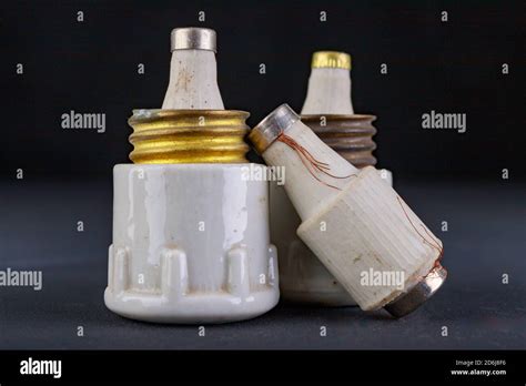 Old ceramic electric fuses. Accessories for the repair of the power network. Dark background ...