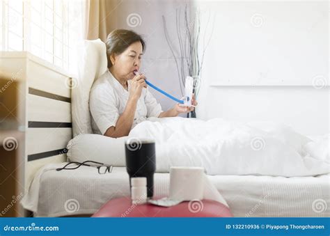 Elderly Asian Woman Patient Using Incentive Spirometer Or Three Balls
