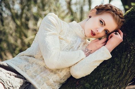 Premium Photo Portrait Of Young Woman Lying On Tree Trunk