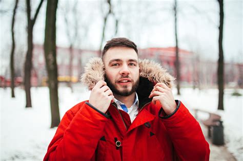 초상화 세련 된 옷을 입고 젊은이 후드와 그의 머리에 모피 빨간색 겨울 자 켓을 입고 수염과 미소의 근접 겨울와 서 리 테마 건강한 생활방식에 대한 스톡 사진 및 기타