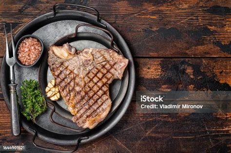 Bbq 구운 티본 또는 포터하우스 쇠고기 고기 허브가 담긴 강철 쟁반에 스테이크 나무 배경입니다 평면도 복사 공간 0명에 대한