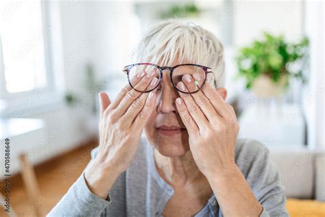 Mature Woman Holds Glasses With Diopter Lensesrubs Her Eyes And Looks