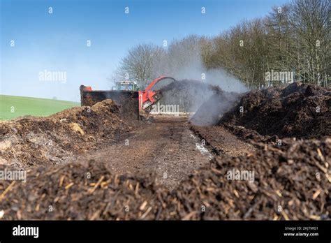 Turning A Manure Heap Over To Make Compost To Spread On Farmland Which