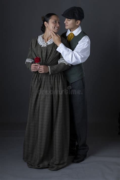 A Romantic Working Class Victorian Couple Standing Together Against A