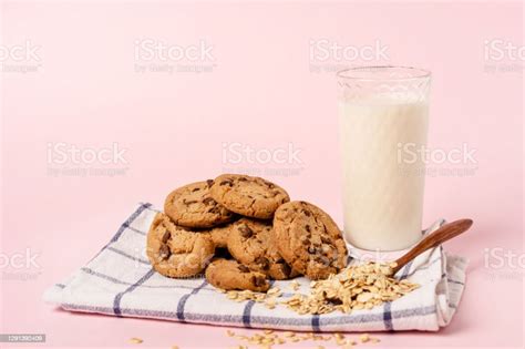 오트밀 초콜릿 칩 쿠키와 파스텔 핑크 배경에 체크 무늬 수건에 우유 한 잔과 텍스트 공간이 있는 갈색에 대한 스톡 사진 및 기타
