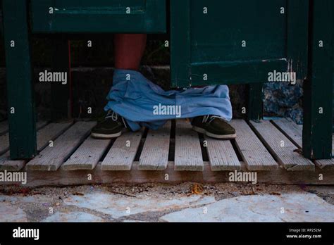The Feet Of A Man Who Sits In The Toilet Public Wooden Wc With Wooden