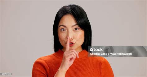 아시아 여성 비밀과 손가락은 거래 이야기 및 배경으로 조용한을위한 상징에 대한 스튜디오 초상화에서 입술에 손가락을 대고 있습니다 소녀 사람 및 모델 아이콘 이모티콘 및