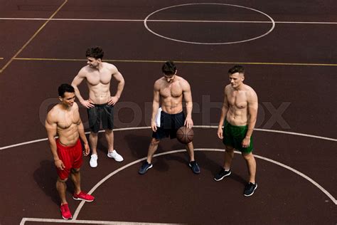 Overhead View Of Four Shirtless Basketball Players With Ball At Basketball Court Stock Image