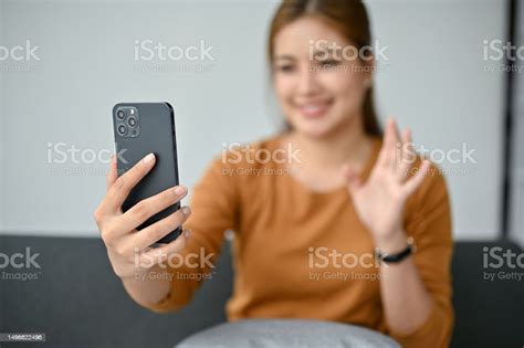거실에서 스마트폰으로 영상통화를 하며 친구들과 이야기를 나누는 여성 25 29세에 대한 스톡 사진 및 기타 이미지 25 29