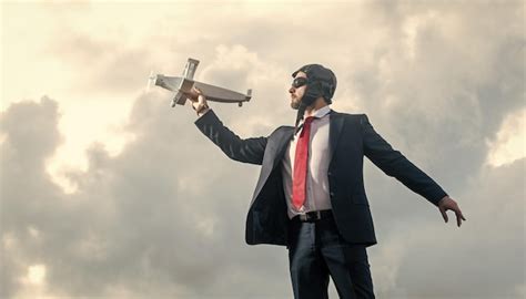 Premium Photo Businessman In Suit And Pilot Hat Launch Plane Toy On