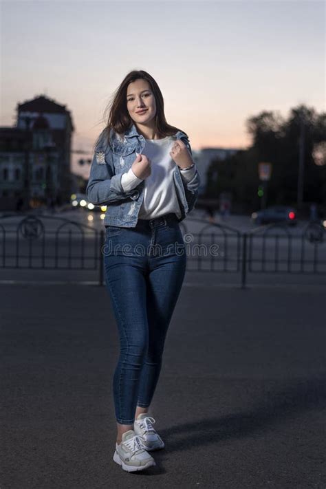 Young Stylish Girl On Evening City Background Young Woman Walking In