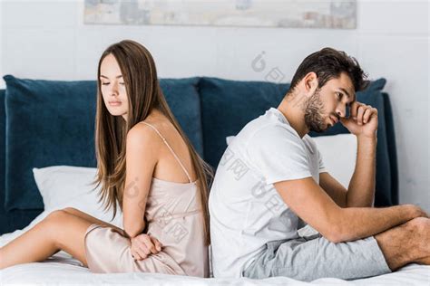 年轻的沮丧夫妇在睡衣坐在床上图片 包图网企业站