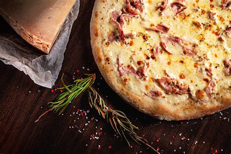 햄 양파 파마산과 화이트 소스와 갈색 나무 테이블에 고 지를 가진 피자에 평면도 조리법 또는 메뉴에 대 한 그림입니다 디자인을 위한 공간을 복사 합니다 조리 된 피자를 제공