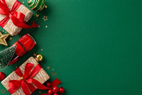 새해의 세련미에 흠뻑 빠져보세요 세련된 공예 종이 선물 상자 호화로운 싸구려 크리스마스 트리를 운반하는 장난감 자동차 녹색 배경에 황금 색종이 조각 프로모션 텍스트 공간을