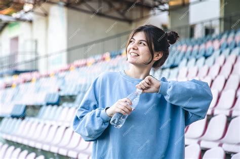 Premium Photo Attractive Young Female Athlete Drinks Water After A