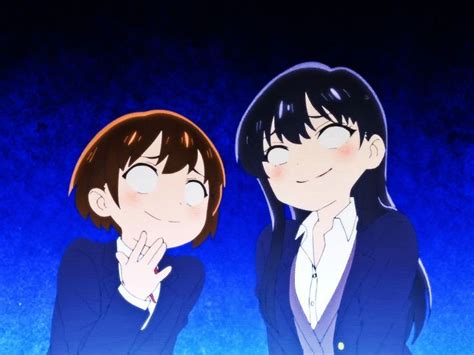 Two People Standing Next To Each Other In Front Of A Dark Blue