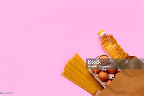 분홍색 테이블에 파스타 해바라기 오일의 종이 가방 세트 공간 평평한 평지 복사 코로나바이러스 검역 격리 기간동안 위기 식품 재고