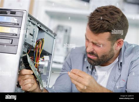 Computer Engineer Working On Broken Console In His Office Stock Photo