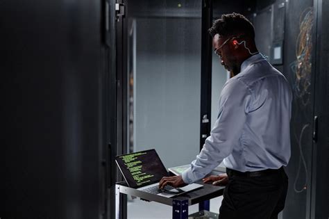 Premium Photo Network Engineer Using Laptop While Setting Up Servers