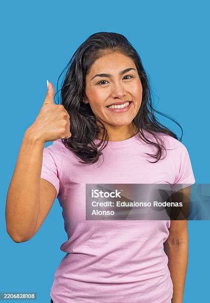 젊은 라틴 여성이 엄지 손가락을 치켜 세우고 파란색 배경에 동의와 긍정을 표현하는 모습 고급에 대한 스톡 사진 및 기타 이미지