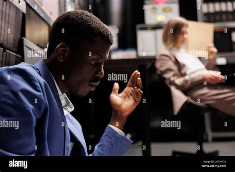 Tired Diverse Colleagues Working Overtime In Arhive Room Analyzing Criminal Case Evidence