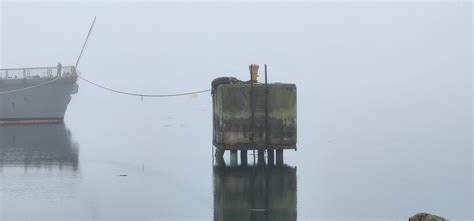Harbor Worker On A Mooring Dolphin With A Ships Line Attached To Its