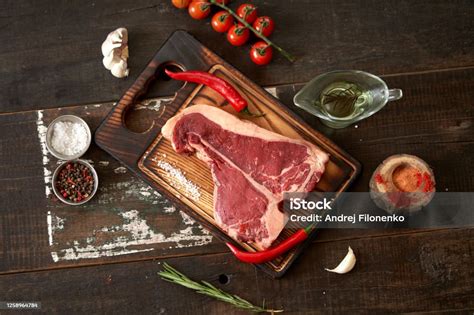 두 개의 붉은 칠리 페퍼 올리브 오일 말린 토마토와 파프리카 소금과 후추 나무 어두운 배경에 토마토와 마늘의 가지 텍스트 장소와