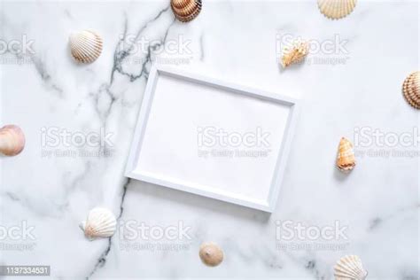 바다 포탄과 대리석 배경에 텍스트에 대 한 복사 공간을 가진 빈 사진 프레임 여름 방학 컨셉 평평한 평 신도 평면도 오버 헤드