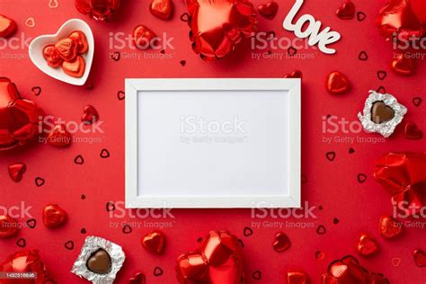 발렌타인 데이 개념입니다 흰색 사진 프레임 하트 모양의 풍선 초콜릿 사탕 접시 비문 사랑과 색종이 조각의 상위 뷰 사진