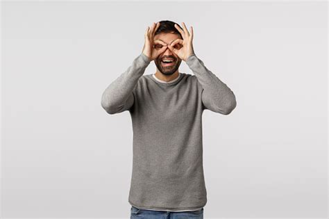 재미 있고 장난스럽고 재미있는 귀여운 수염을 가진 아버지가 장난을 치는 귀여운 수염을 기리고 눈 위에 손가락으로 안경이나 쌍안경