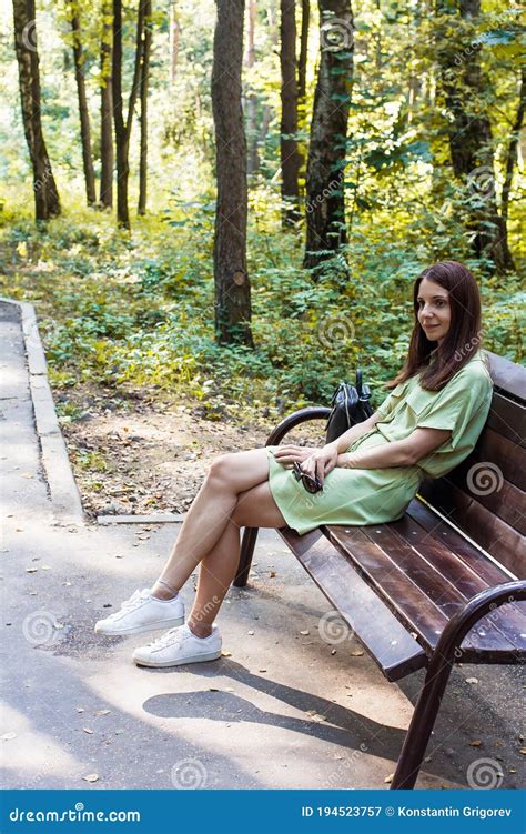 Young Beautiful Woman Sitting On Bench In Park Shot Of A College